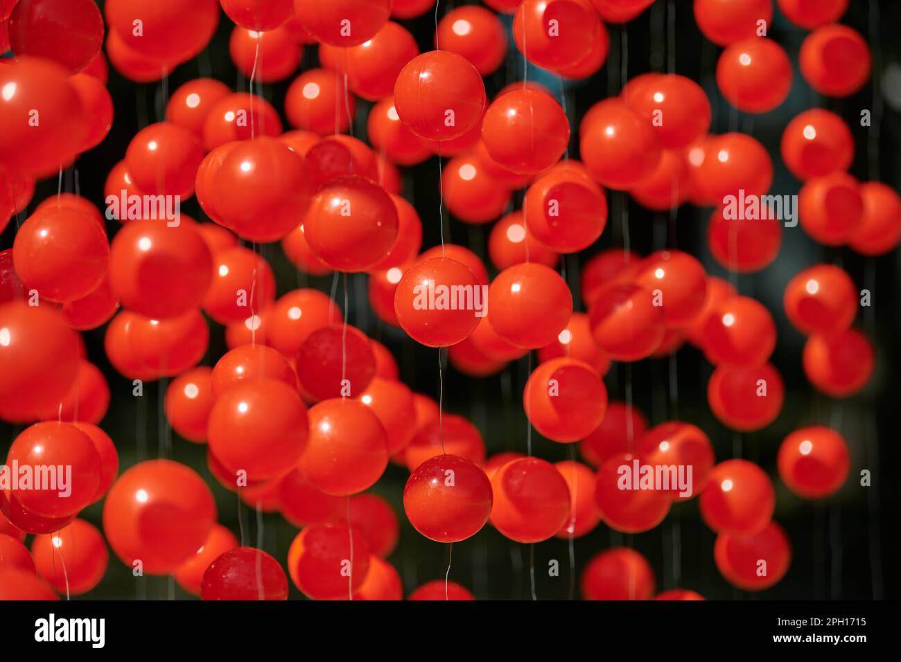 Red balls suspended on wire, outdoor art object symbolizing blood cells ...