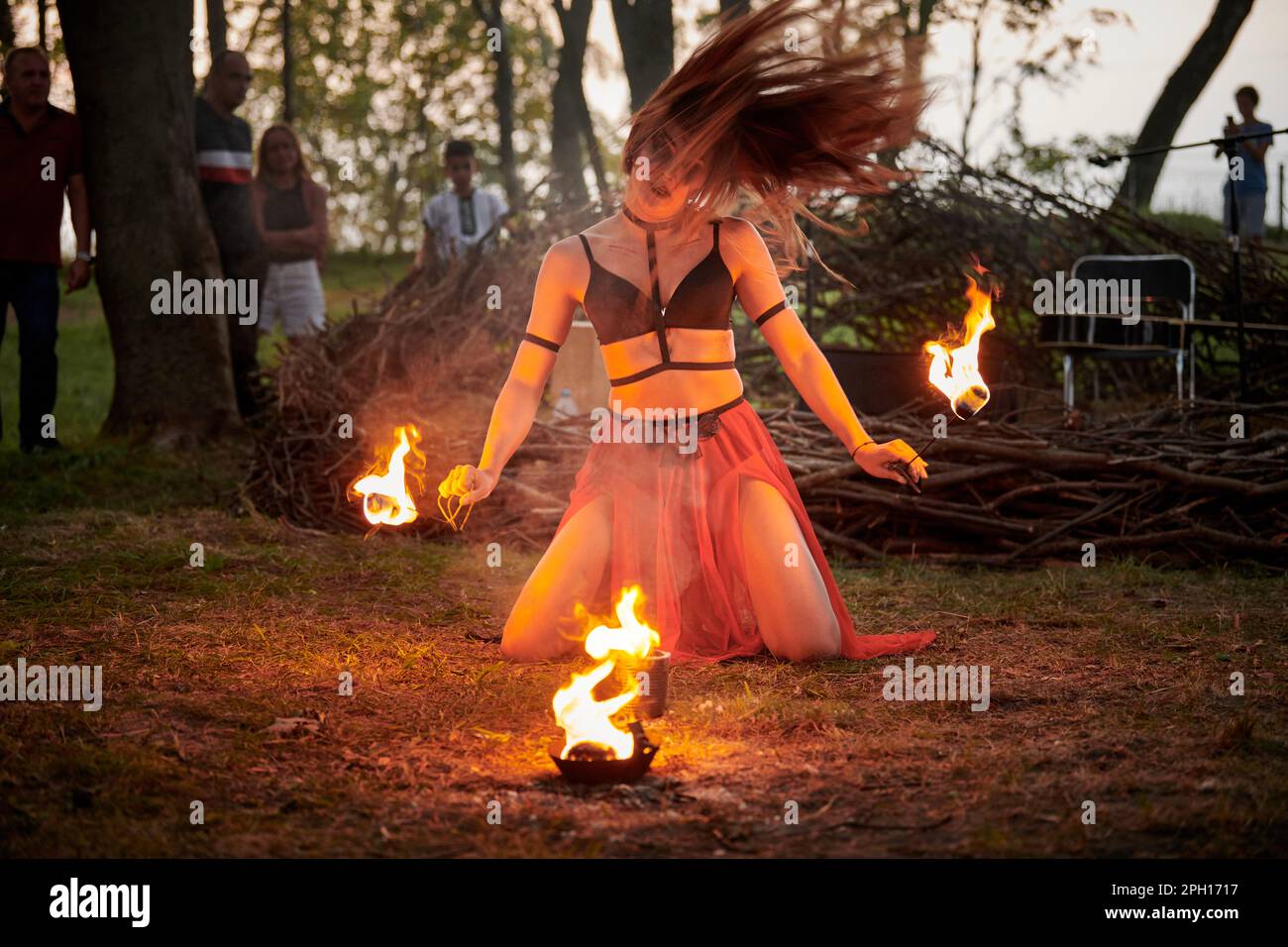 Girl fire dancing performance at outdoor art festival, smooth movements ...