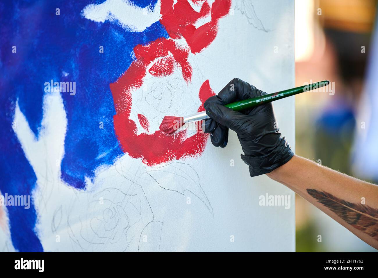 Artist hand in black gloves holds paint brush and draws abstract ...