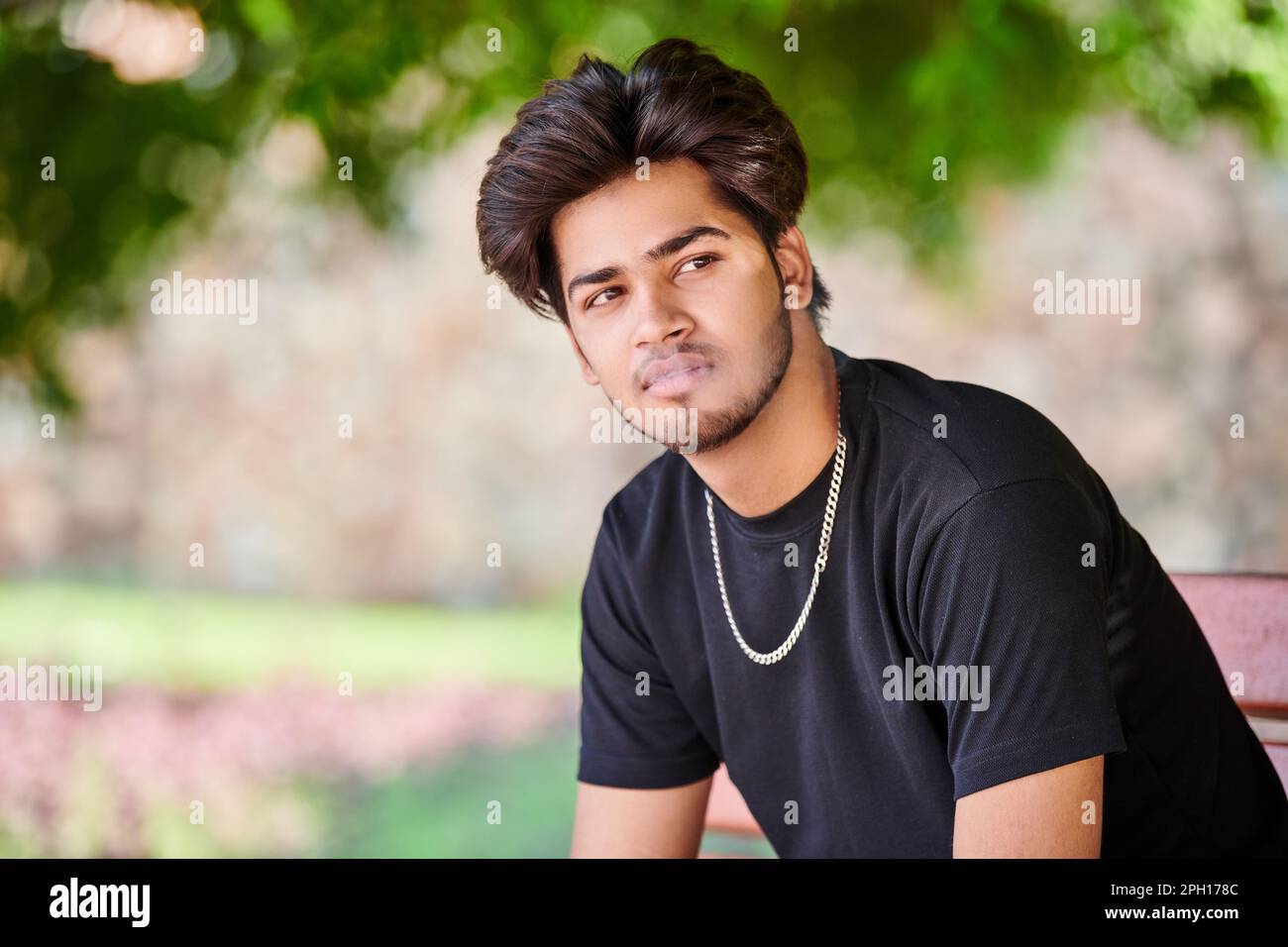 Attractive indian man smoker exhales cigarette smoke portrait in black ...