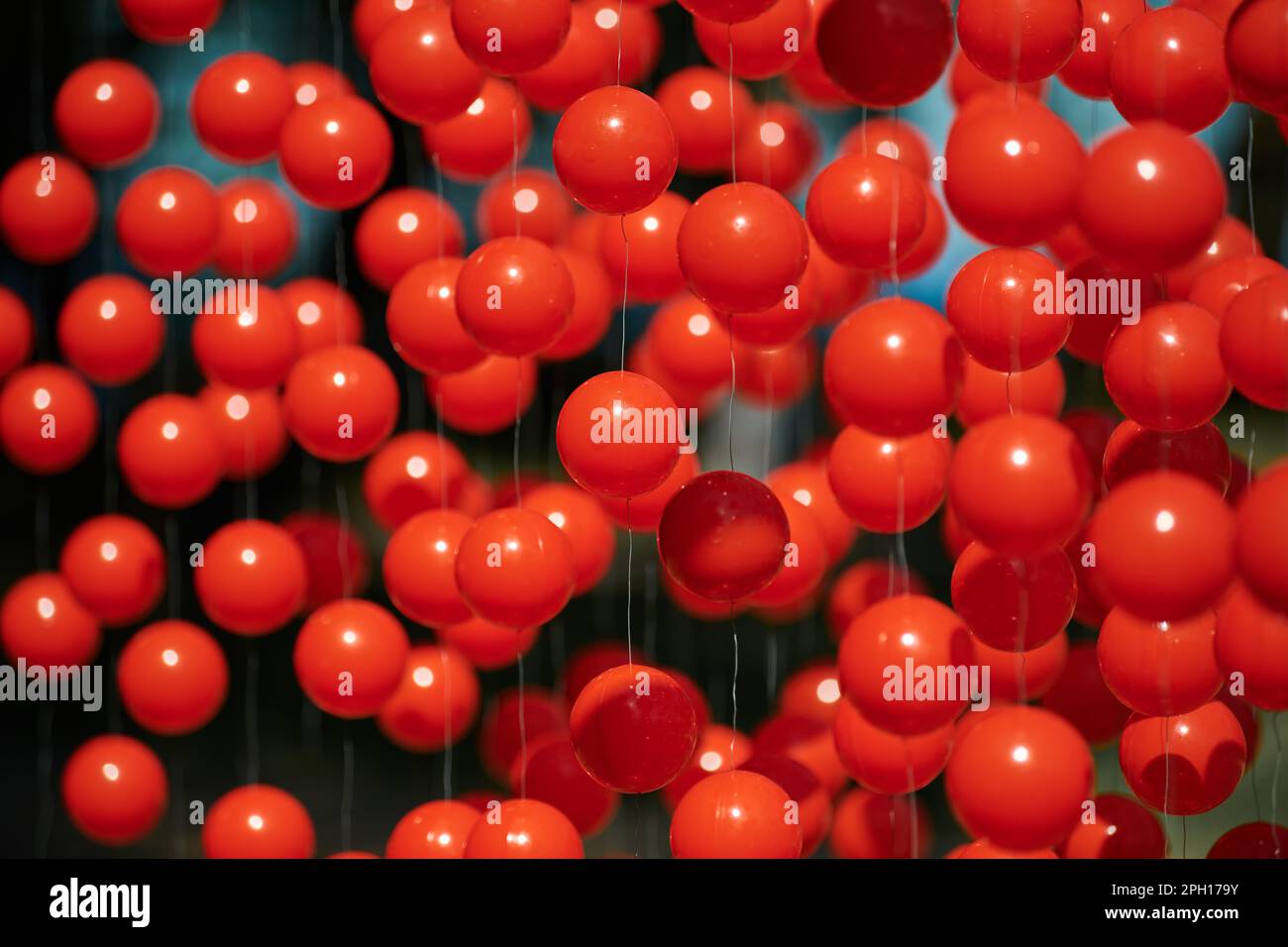 Red balls suspended on wire, outdoor art object symbolizing blood cells ...