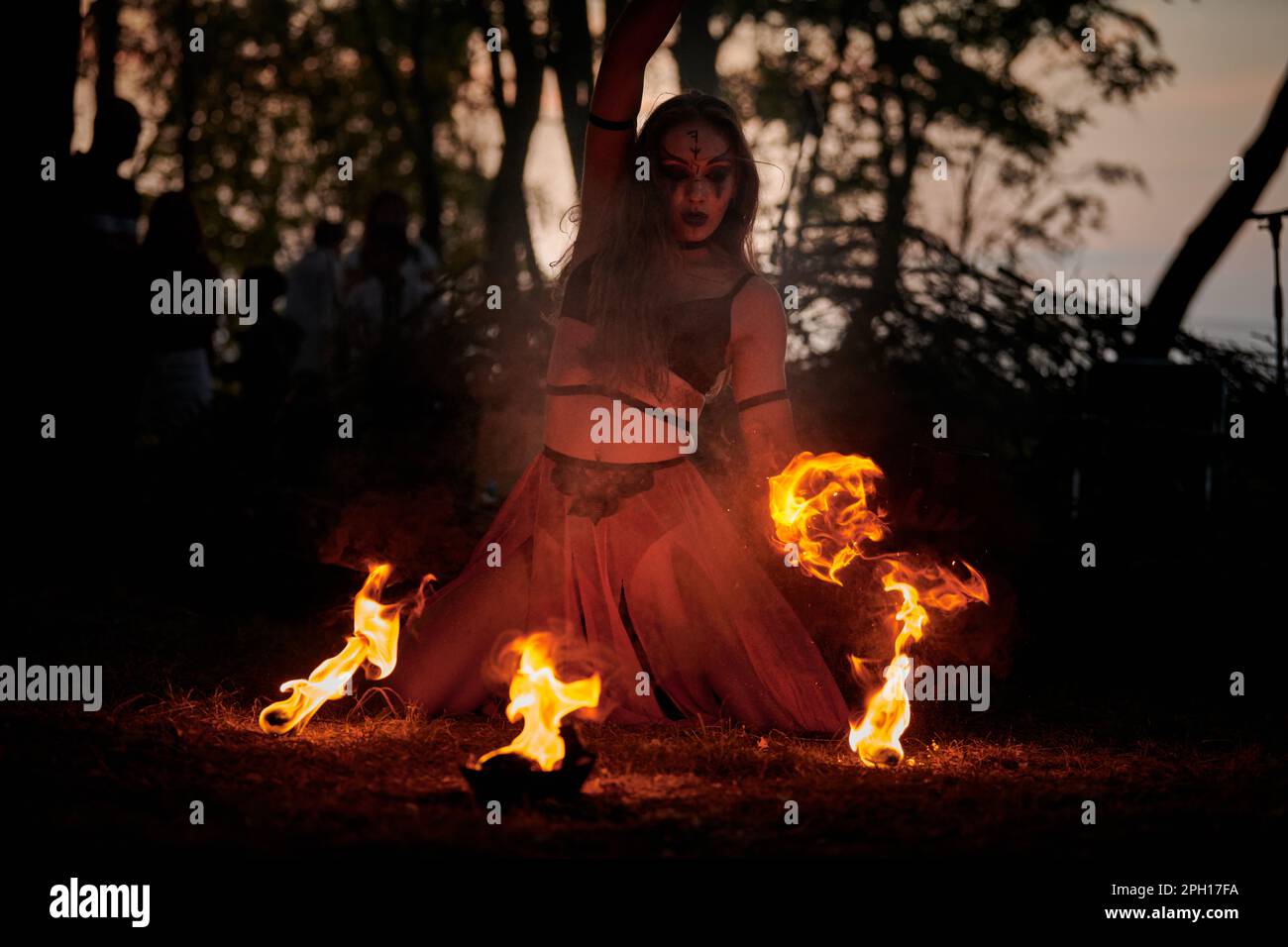 Girl fire dancing performance at outdoor art festival, smooth movements ...