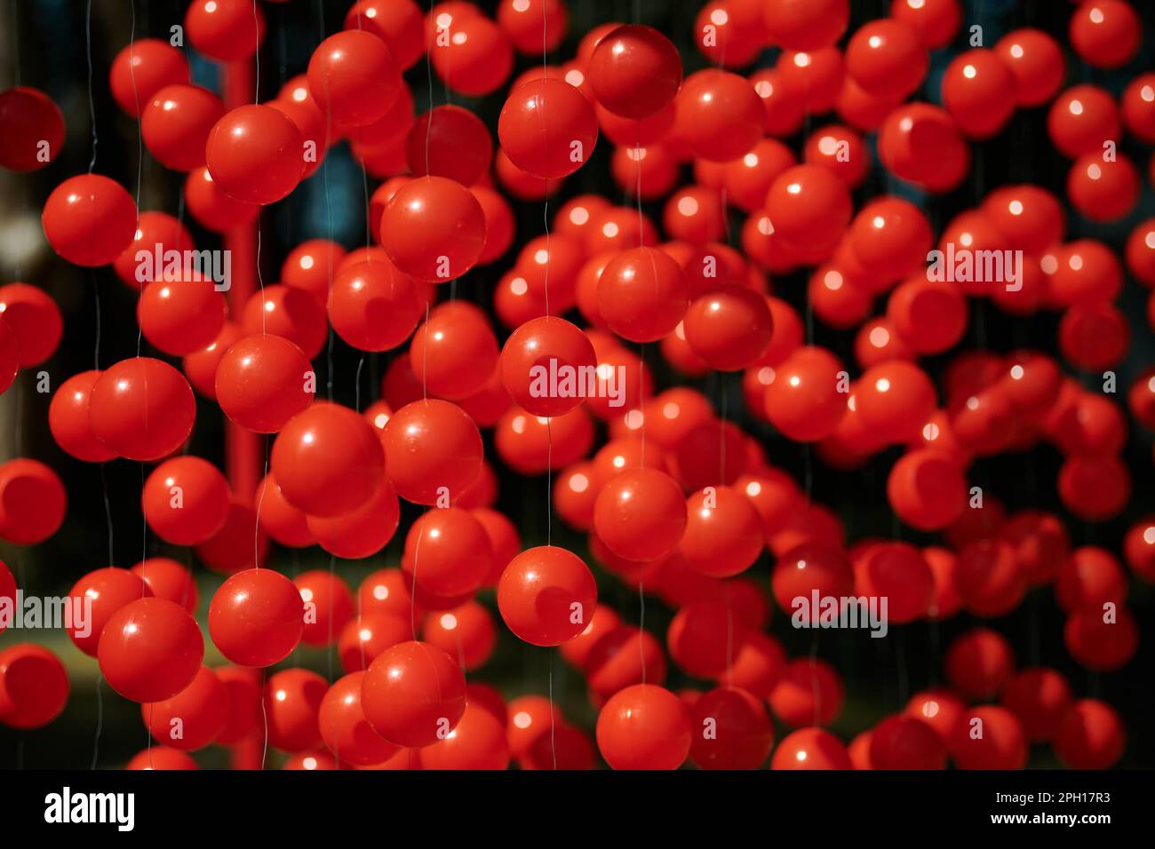 Red balls suspended on wire, outdoor art object symbolizing blood cells ...