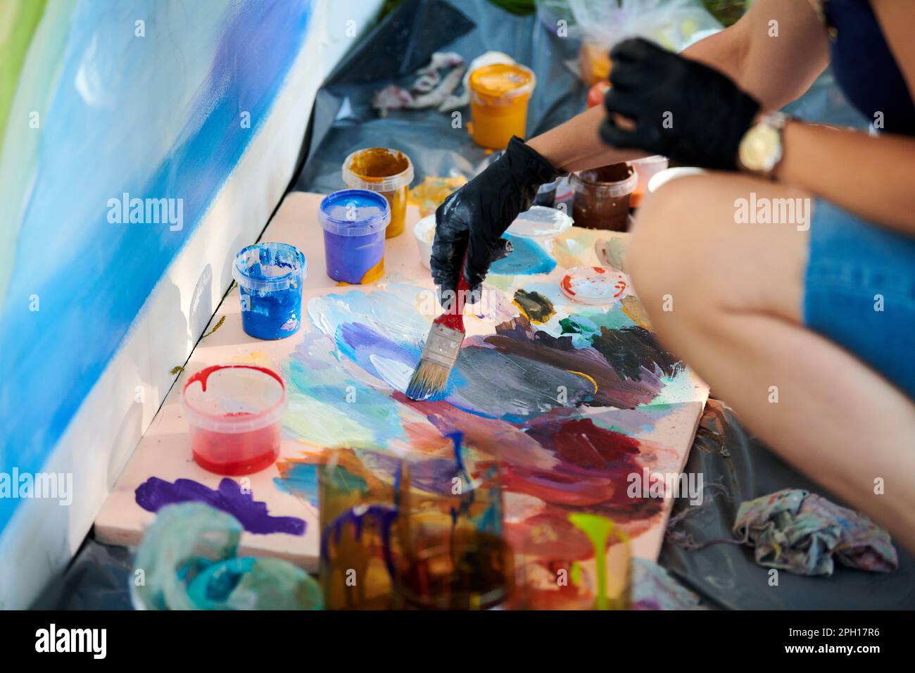 Artist hand in black gloves holds paint brush and choose color from ...