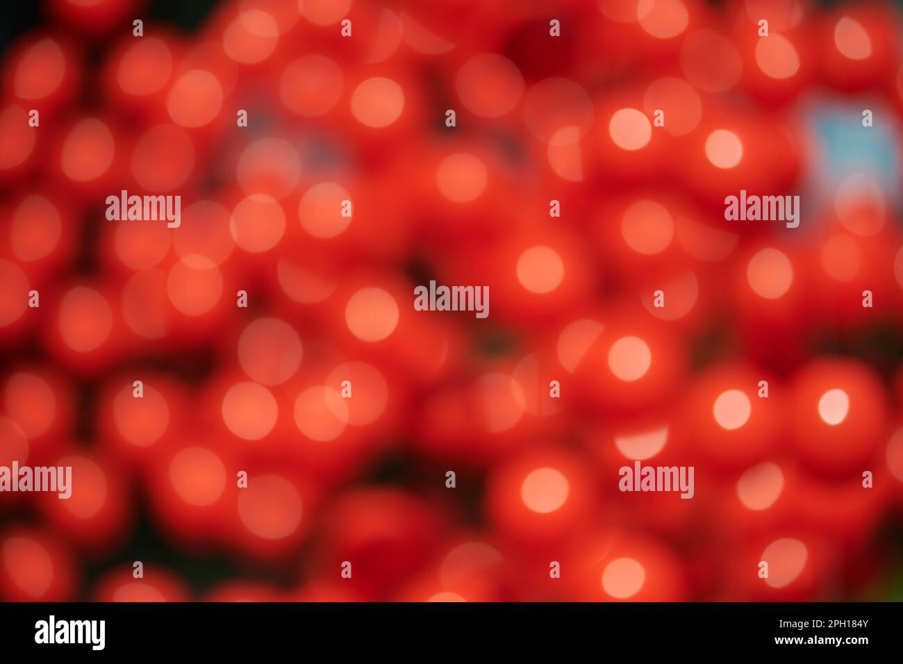 Blurred defocused red balls suspended on wire, outdoor art object ...