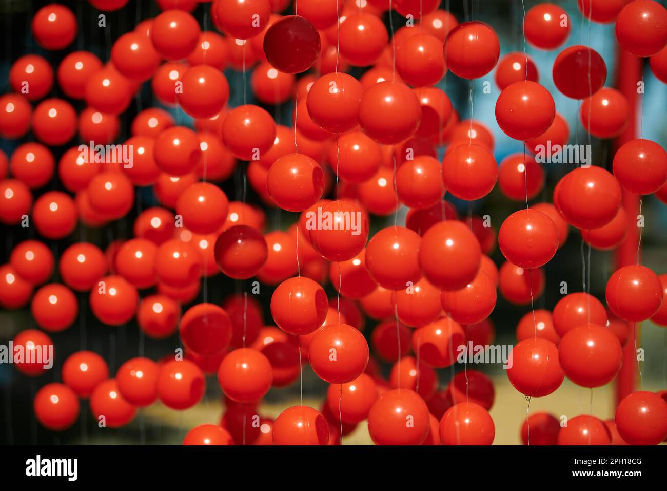 Red balls suspended on wire, outdoor art object symbolizing blood cells ...