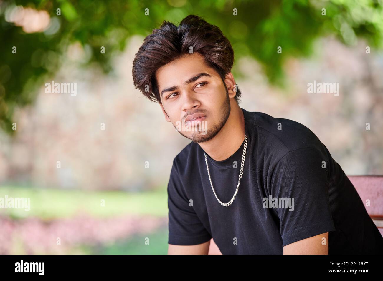 Attractive indian man smoker exhales cigarette smoke portrait in black ...