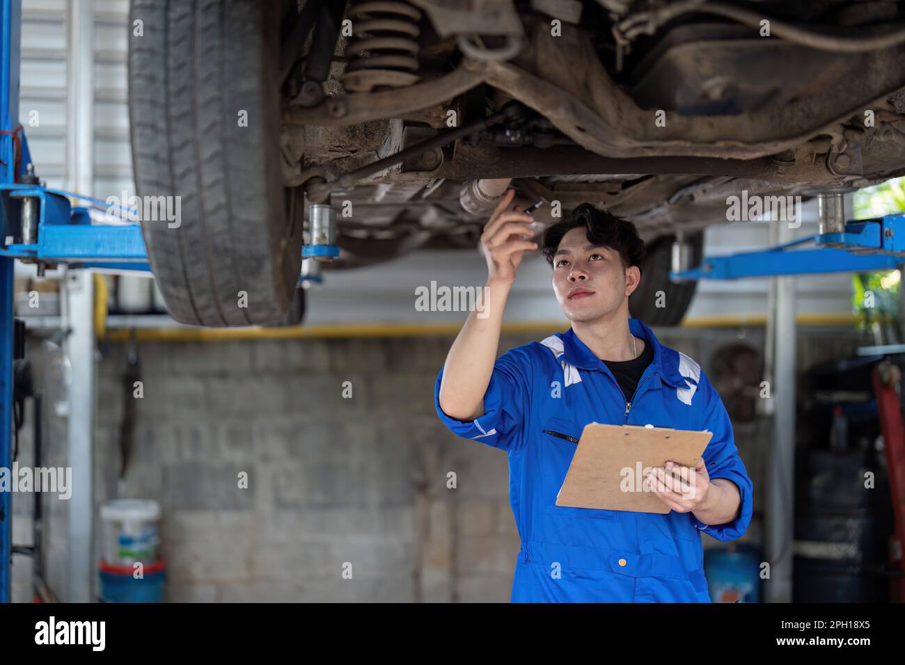 Vehicle service maintenance asian man checking under car condition in ...