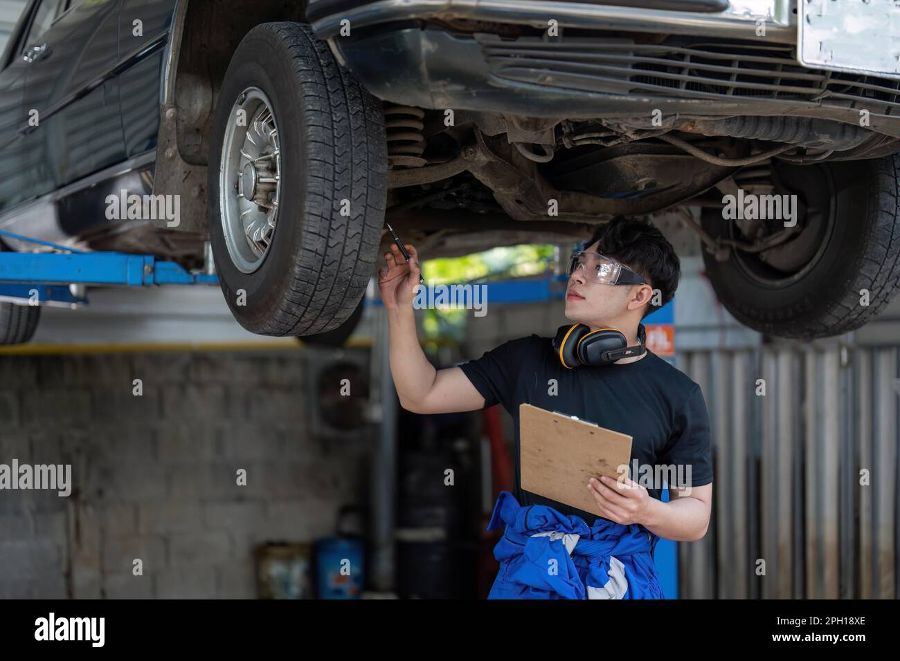 Vehicle service maintenance asian man checking under car condition in ...