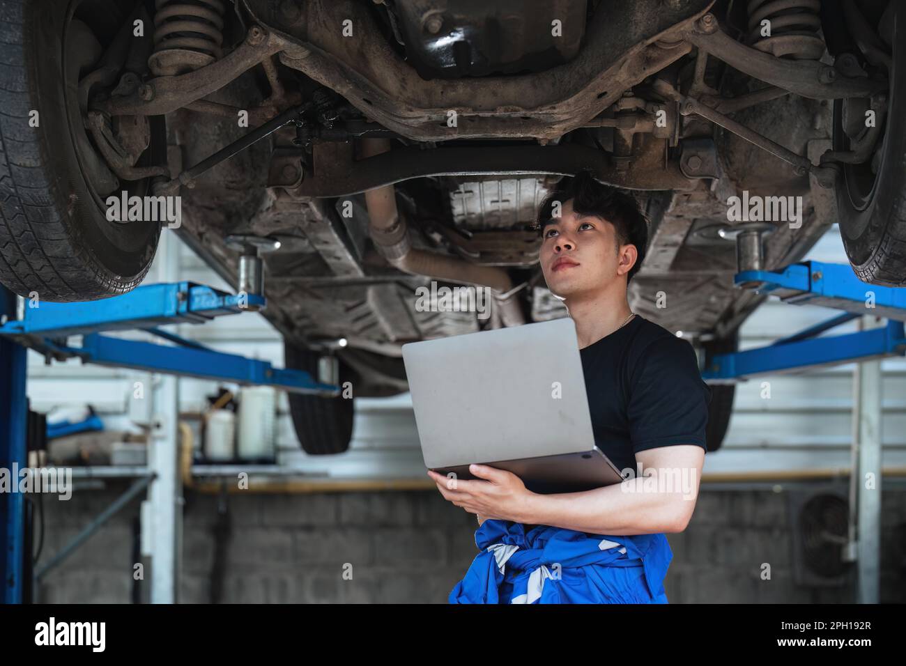 car mechanic car suspension detail of lifted automobile at repair ...