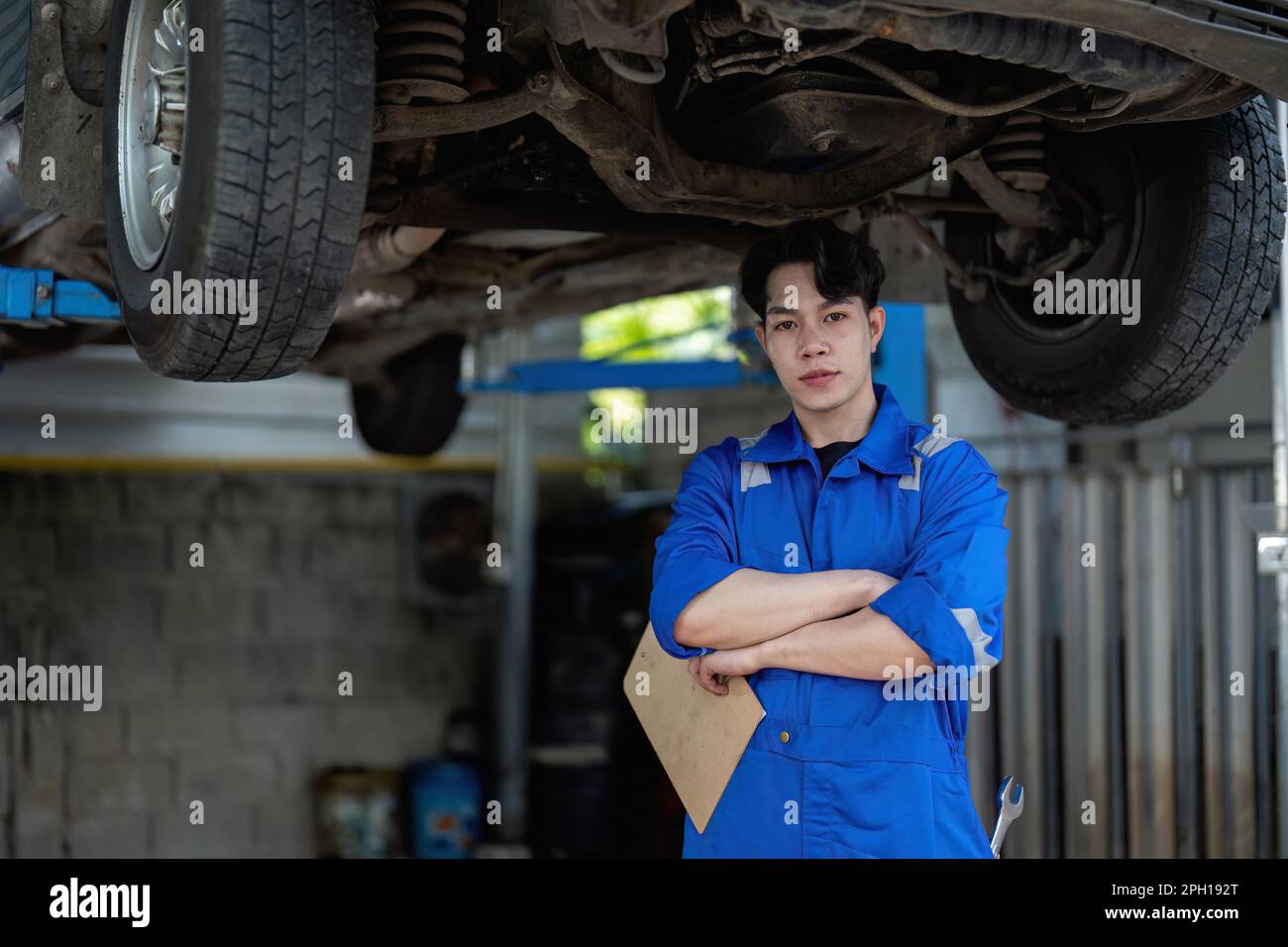 Vehicle service maintenance asian man checking under car condition in ...