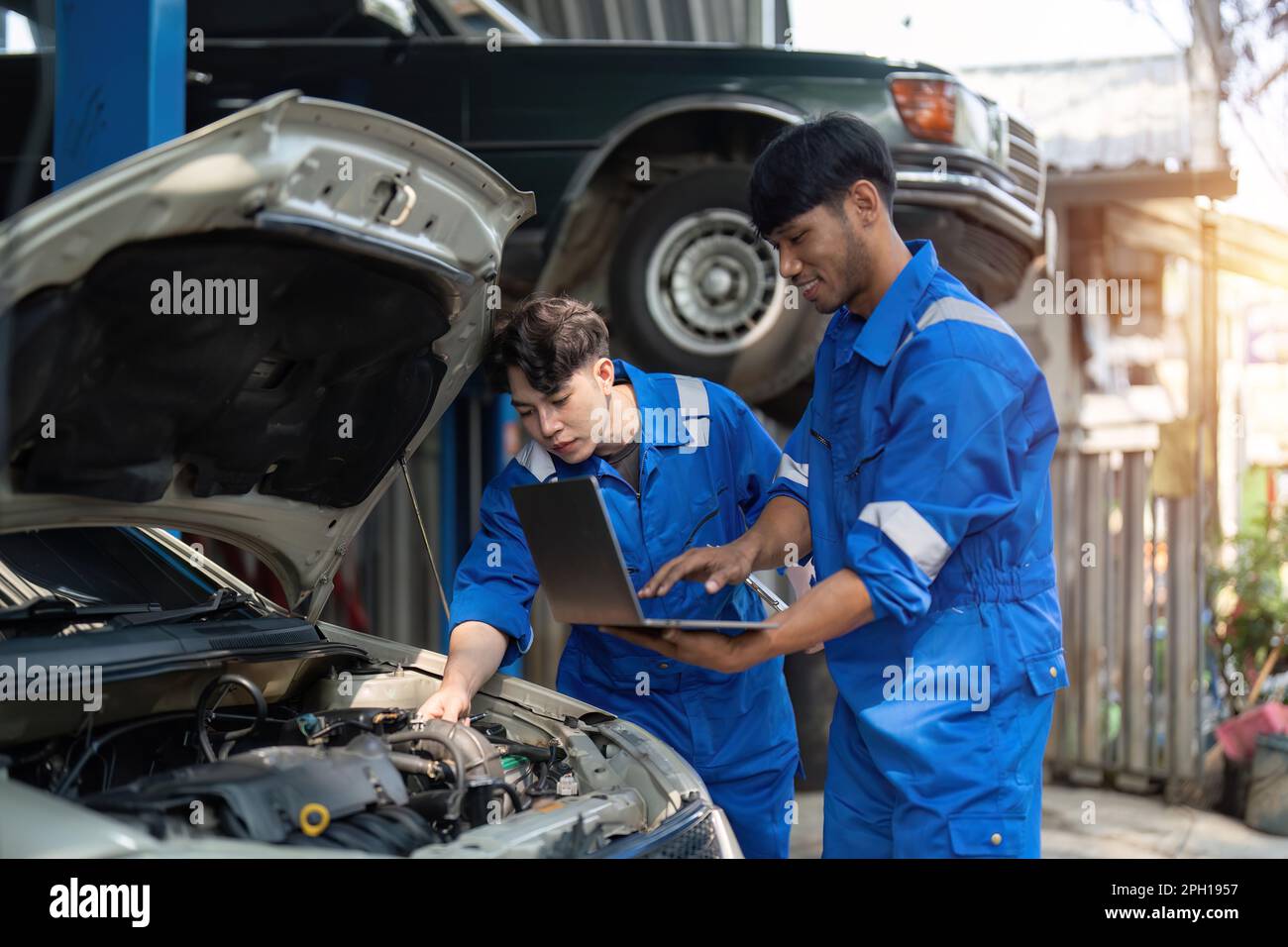 Mechanic man shows report to the asian coworker at garage, A man ...