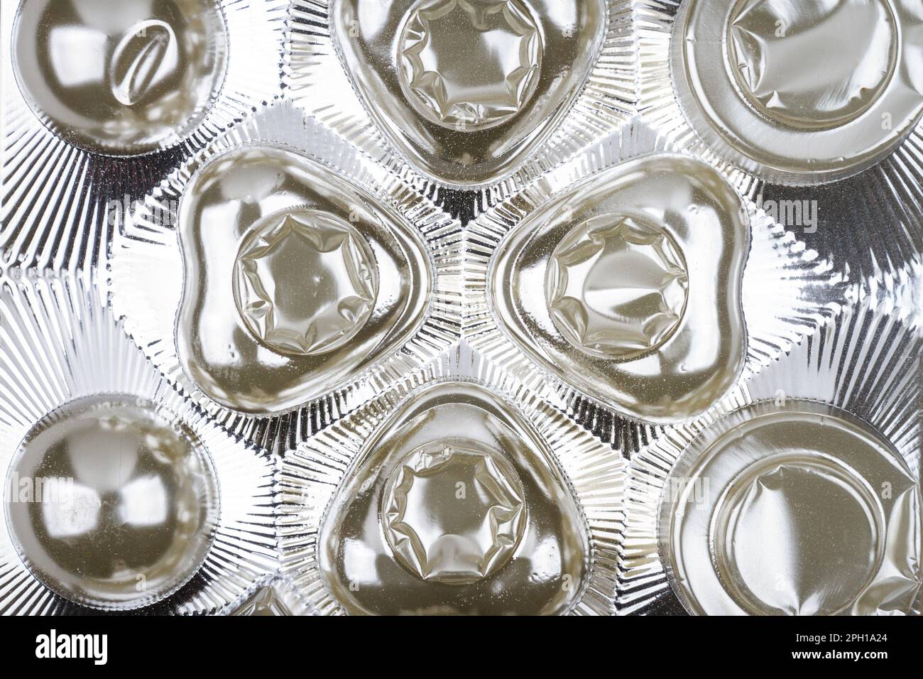 Close up shot of empty box of chocolates. Shiny gold plastic texture of ...