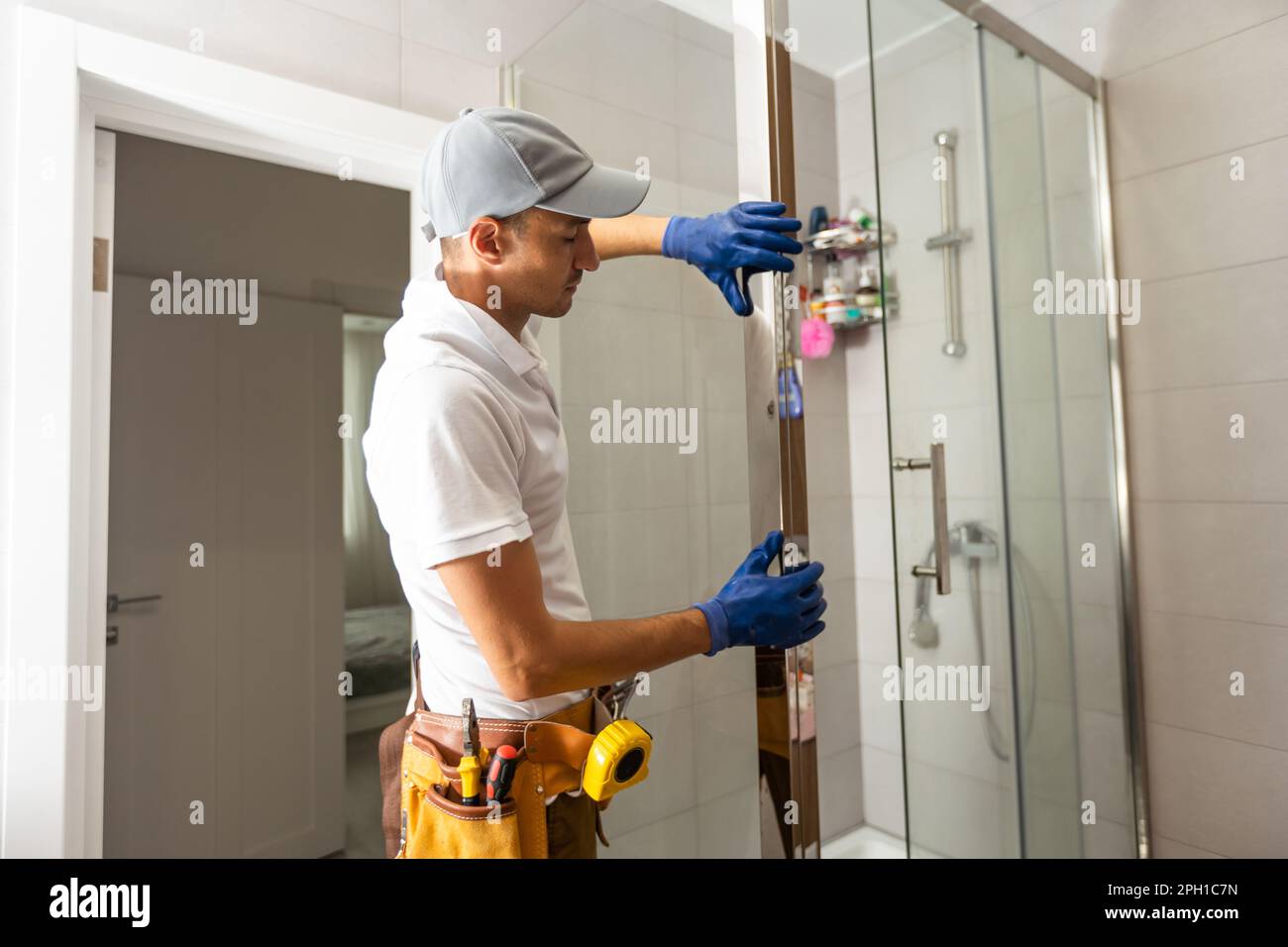 Workers are installing glass door of the shower enclosure Stock Photo ...