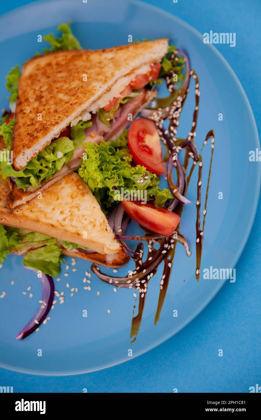 Breakfast sandwich toast with salad. Blue background. Bread, beakon ...