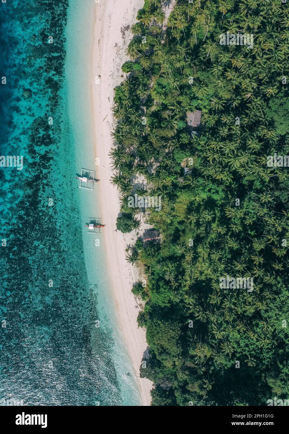 An aerial view of a tropical island surrounded by crystal clear, azure ...