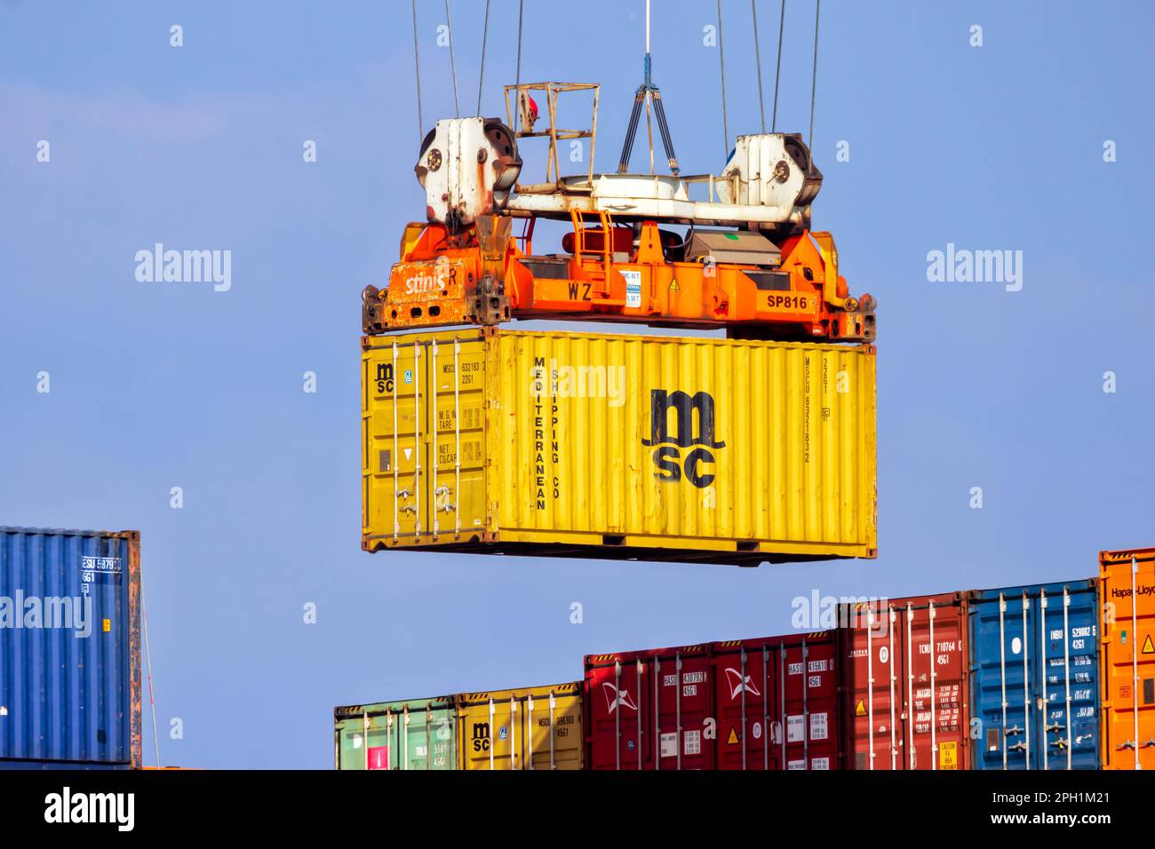 Crane operator unloading a sea container from a cargo ship in the Port ...