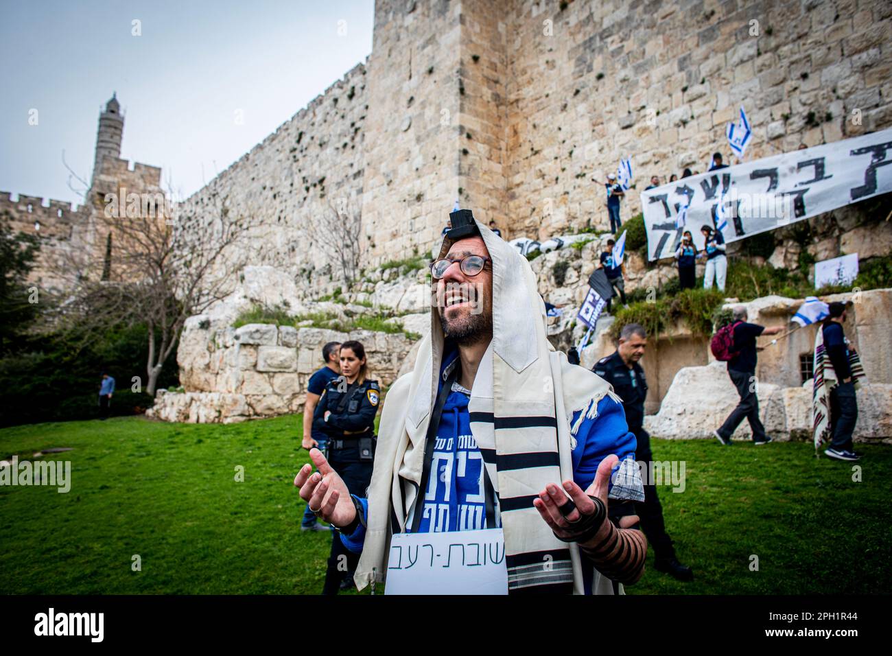 A protester covered with a prayer shawl and a placard that says: Hunger ...