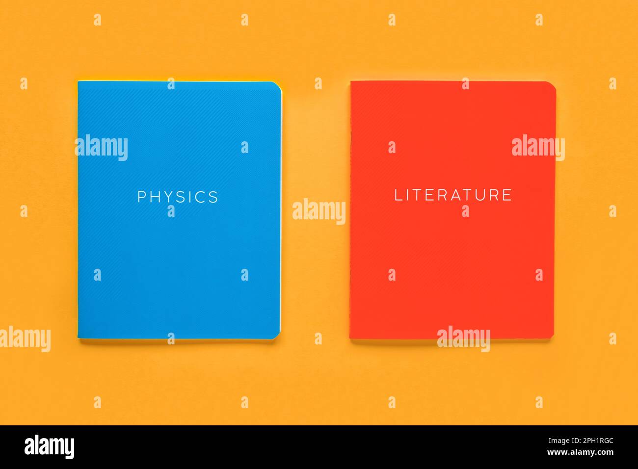 Multicolored exercise books over the orange background, close up ...