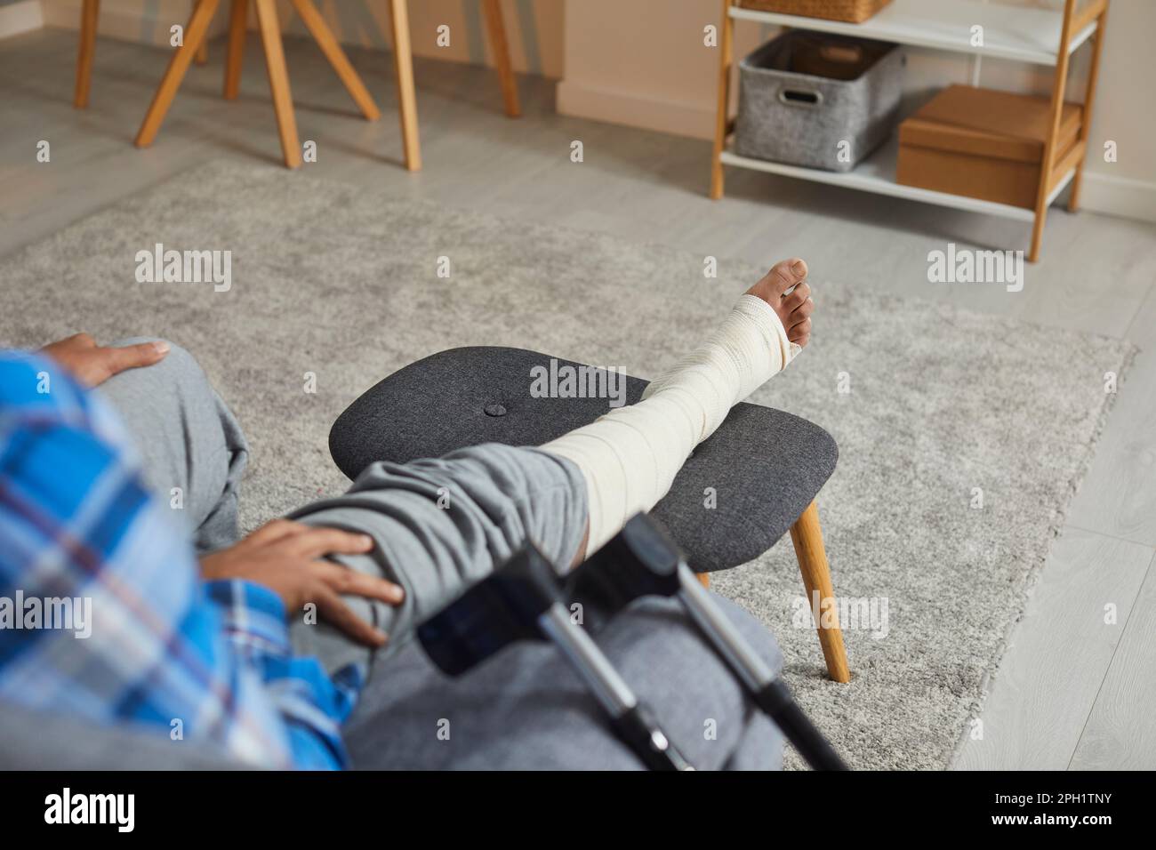 Young African American man with an injured leg and foot sitting on the ...