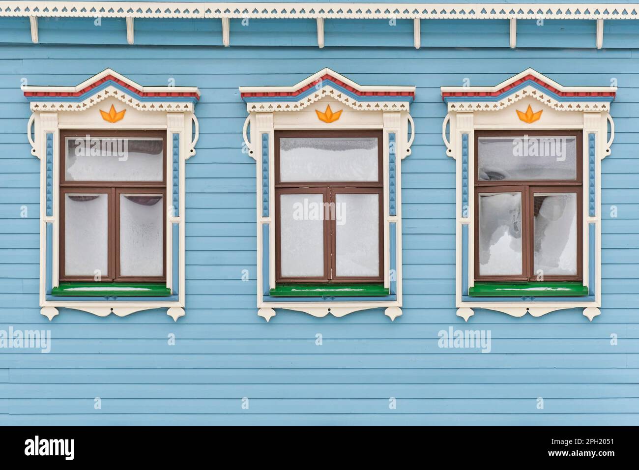 Frozen windows with carved wooden architraves. Facade of typical ...