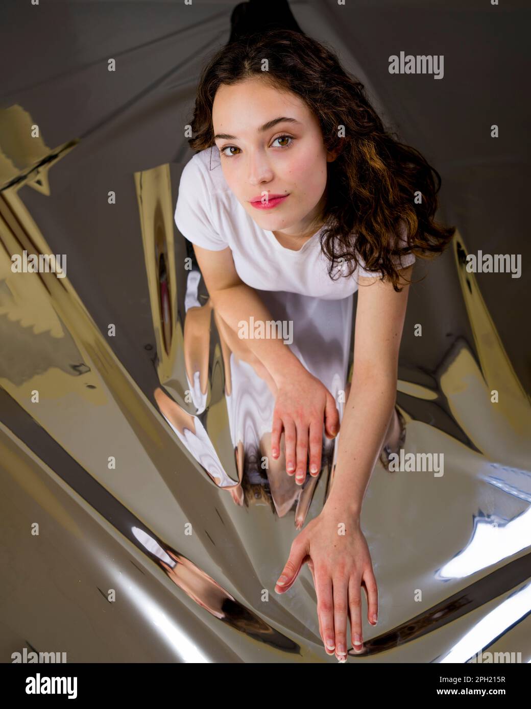 Beautiful Teenage Girl Lying Prone on a Reflective Silver Mylar Sheet ...