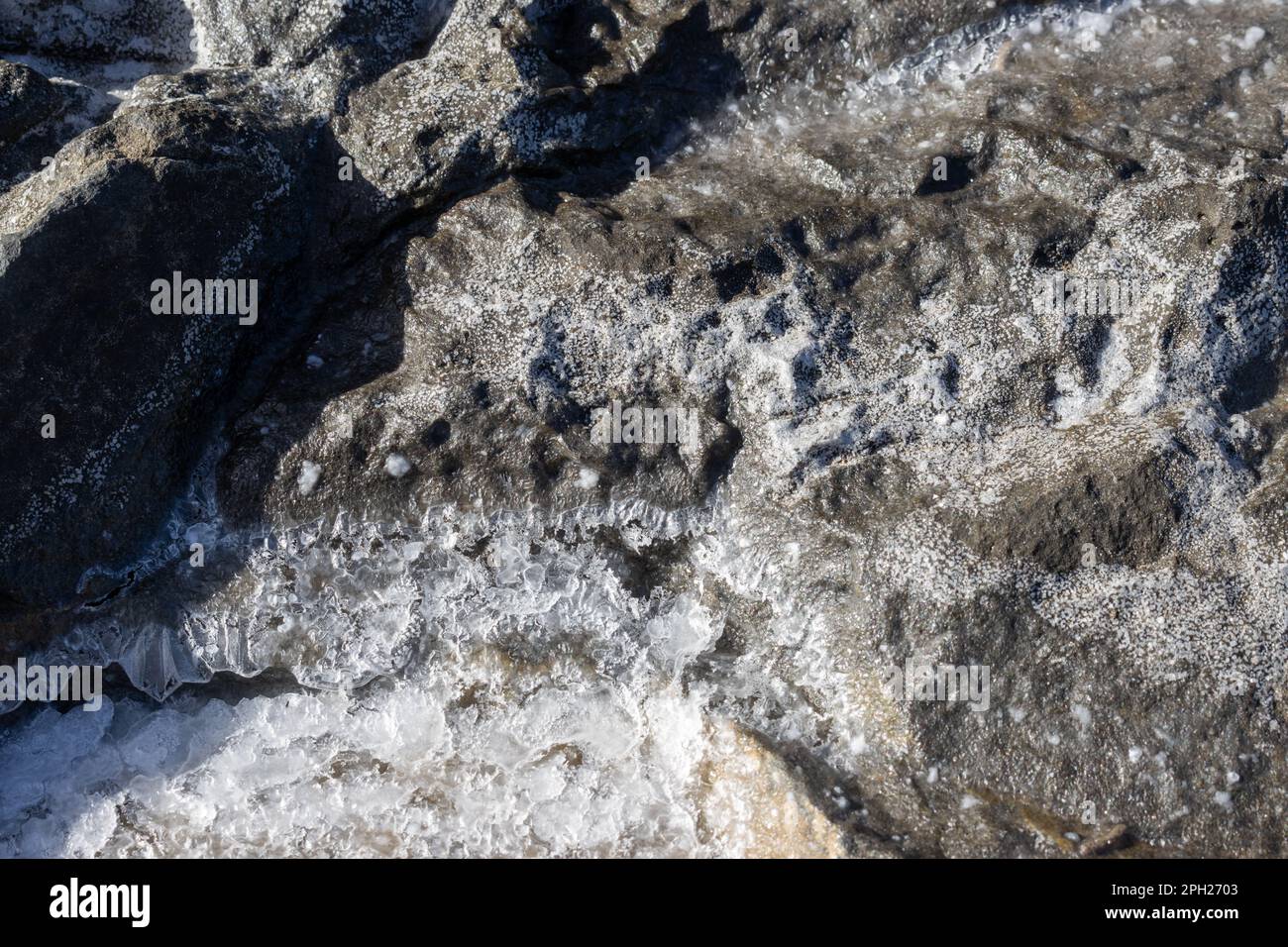 Black rocks on the coast of Atlantic ocean. Crystals of sea salt ...