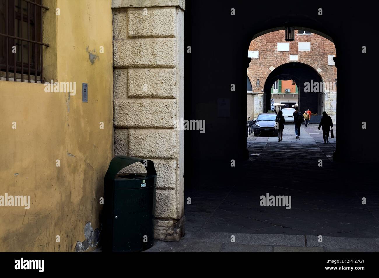 Covered alley in the shade between square in an italian city with ...