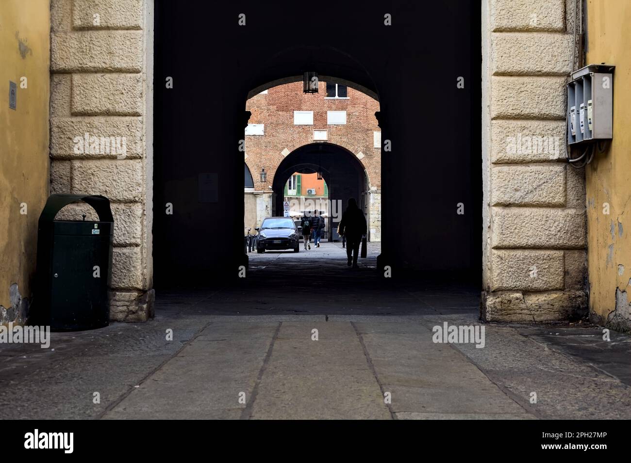 Covered alley in the shade between square in an italian city with ...