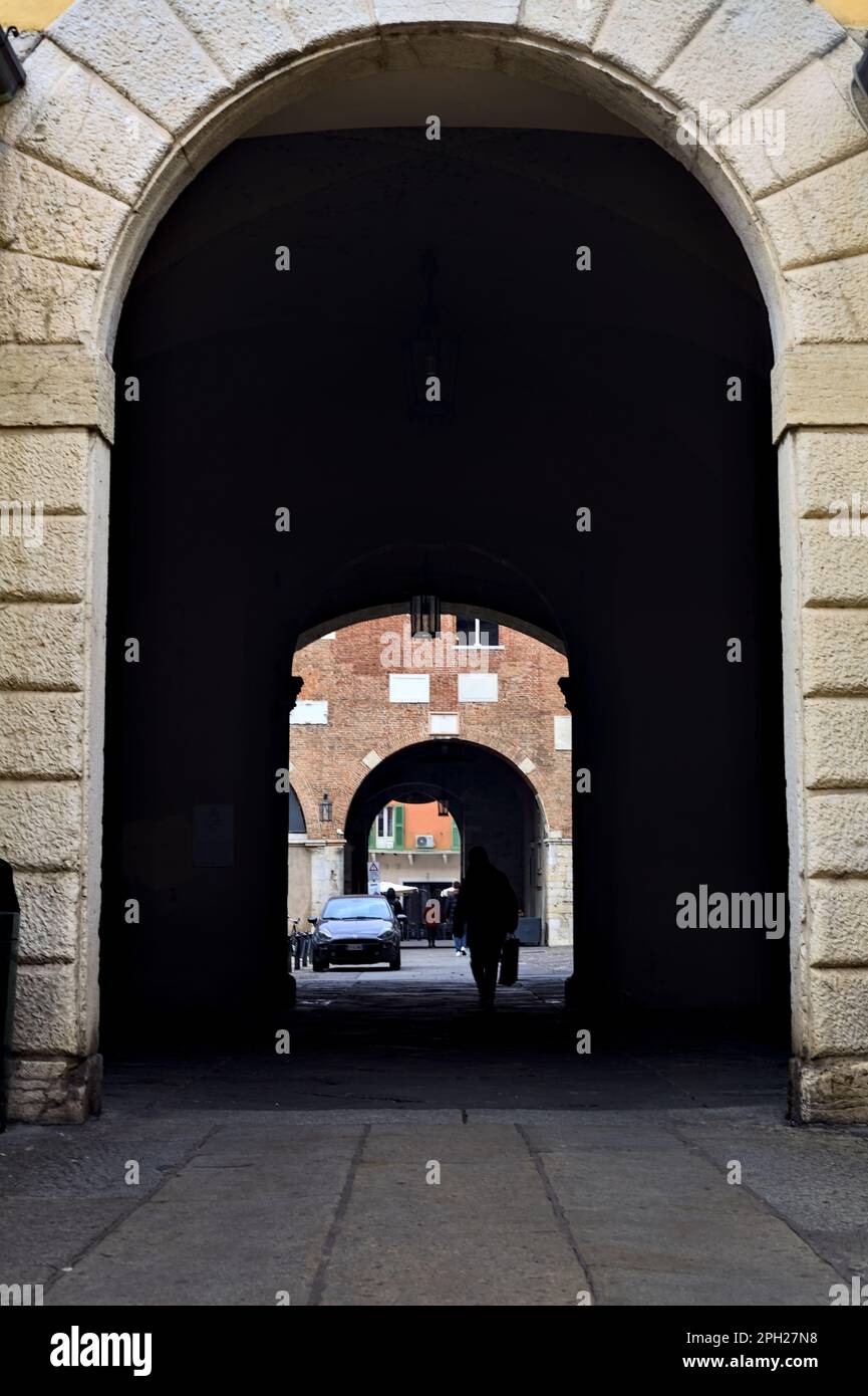 Covered alley in the shade between square in an italian city with ...