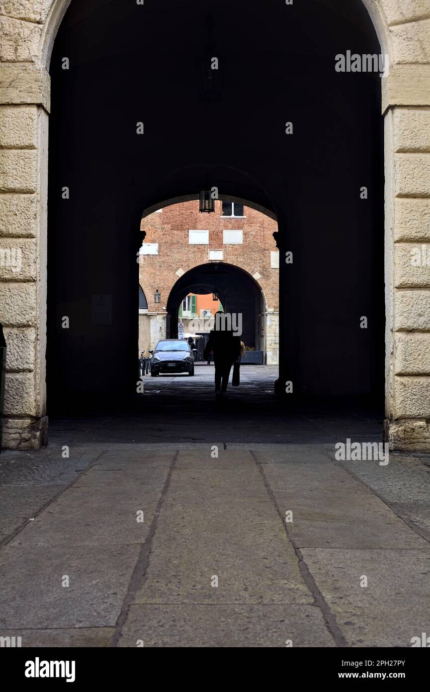 Covered alley in the shade between square in an italian city with ...