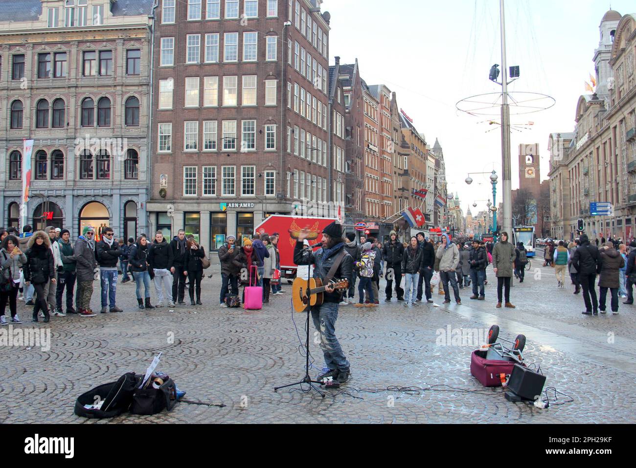 Scene with a street musician in the Dam Square, snowless winter evening ...