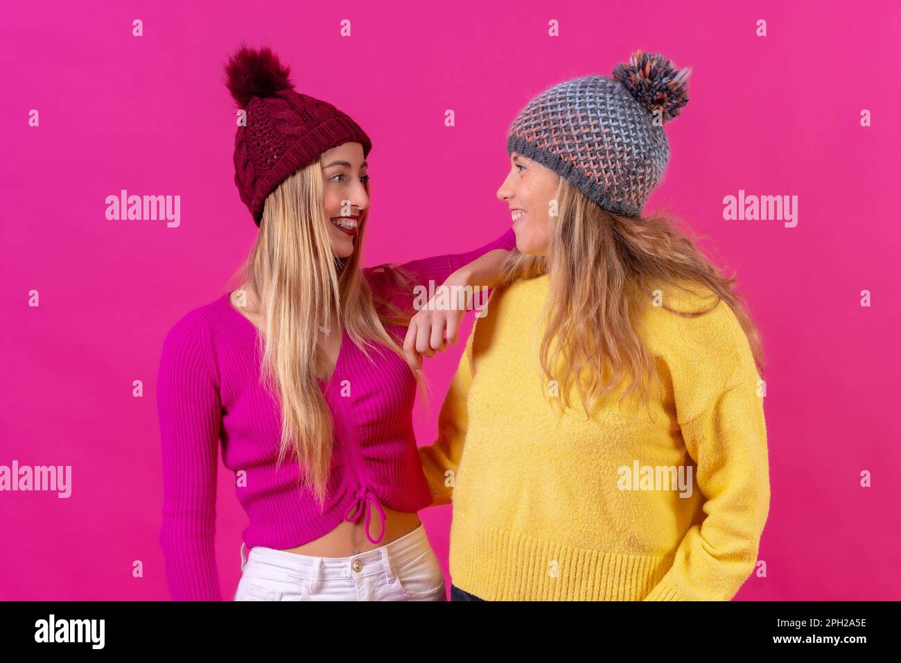 Females with hats and colorful blouses hugging each other isolated on ...