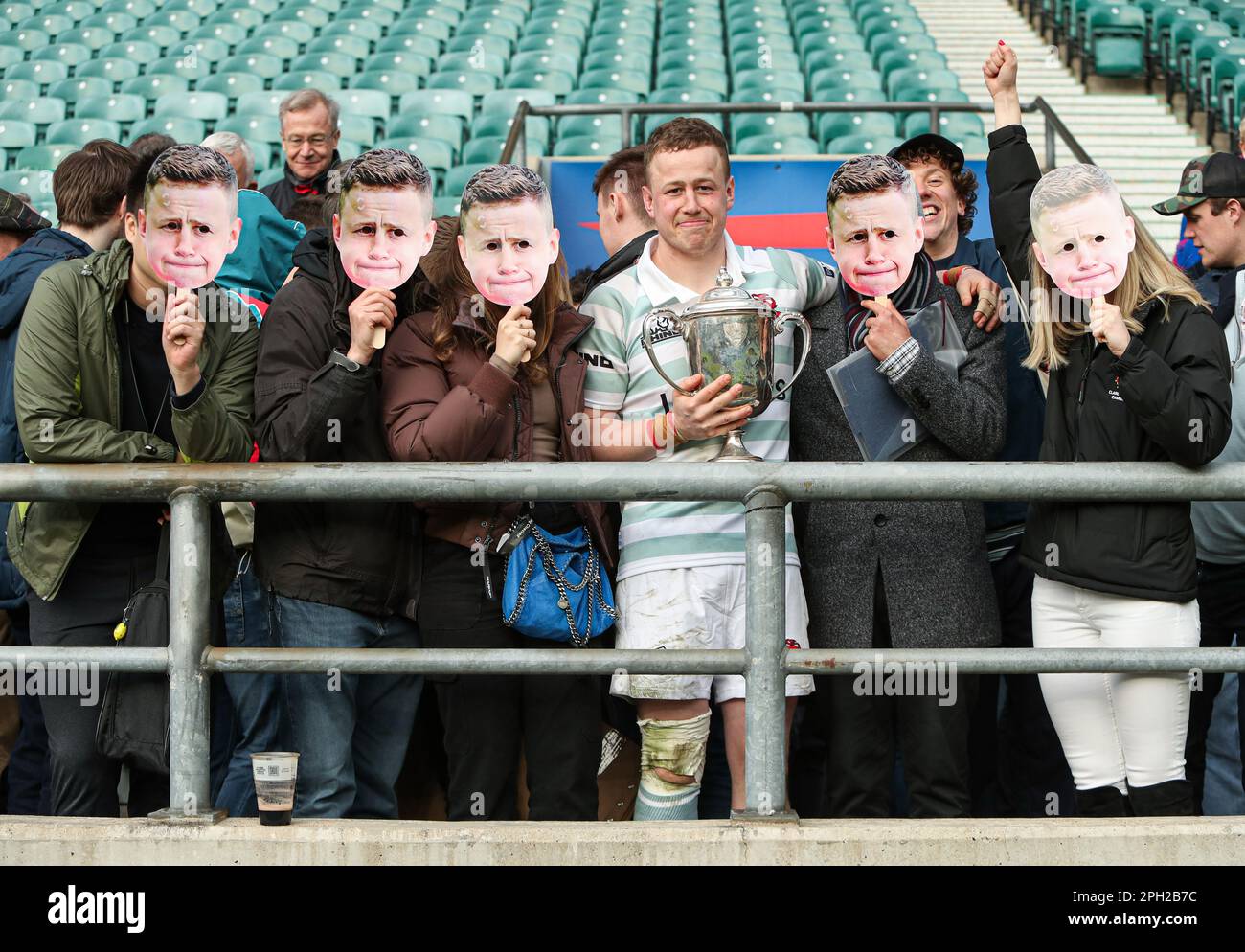 Cambridge captain Ben Gompels with fans holding face masks of his face ...