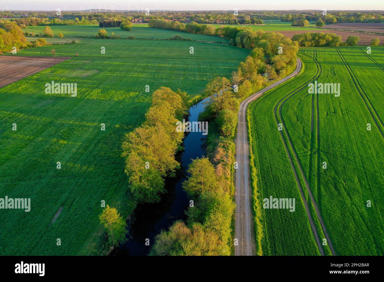 An aerial view of a picturesque rural farmstead with a river winding ...