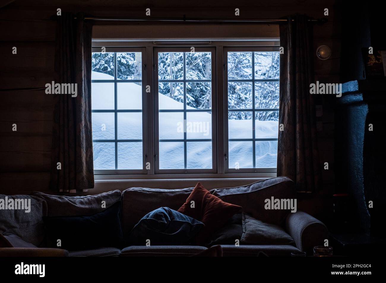 View through the window from cozy wooden cabin to snowy mountains ...