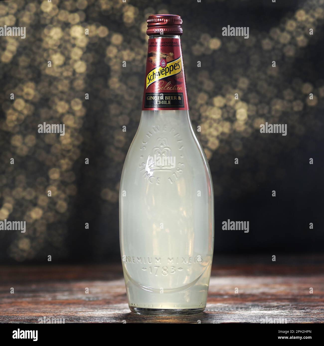 Koszalin, Poland, March 25, 2023. Schweppes Glass bottle on an abstract ...