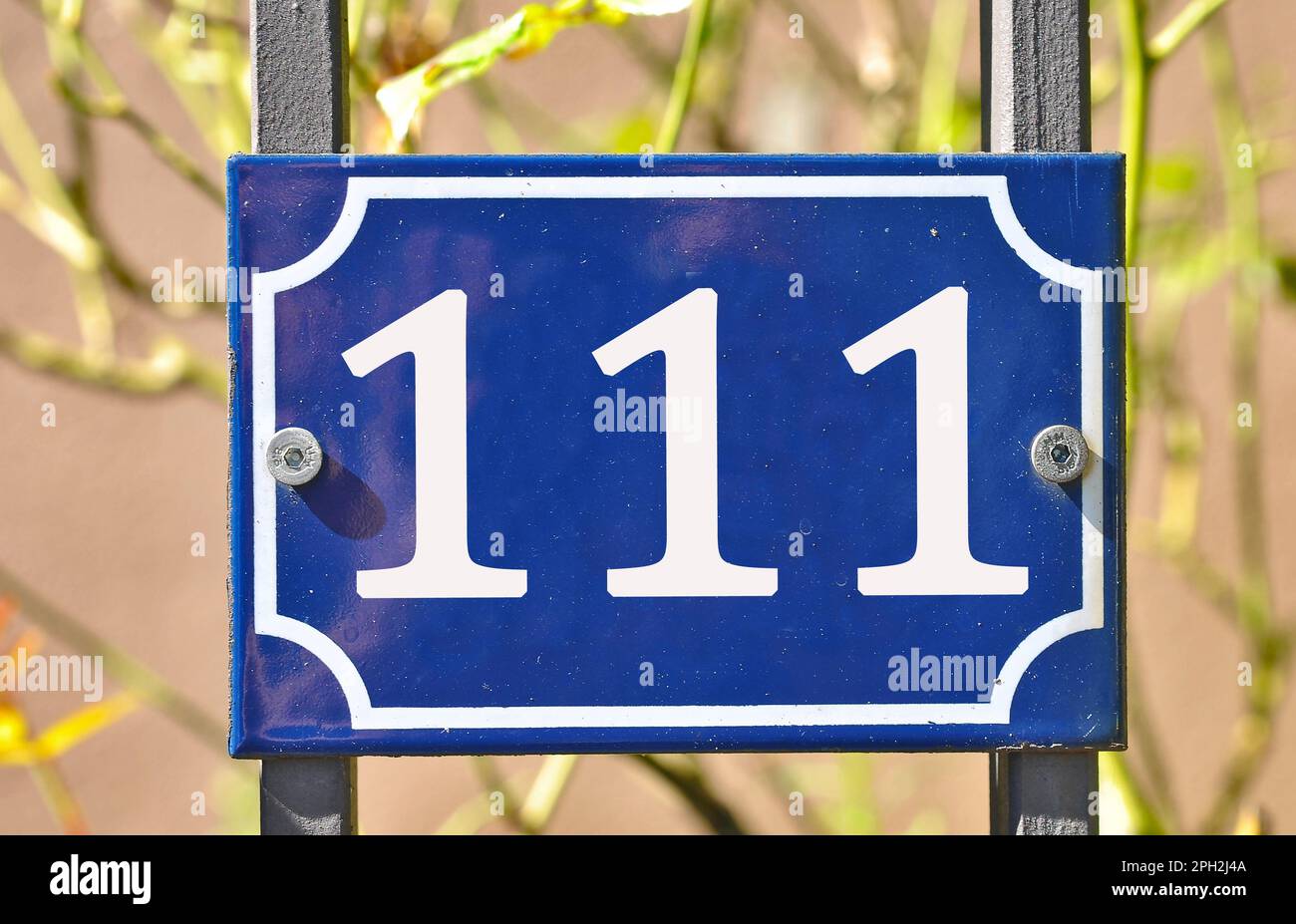 A blue house number plaque, showing the number hundred and eleven (111 ...