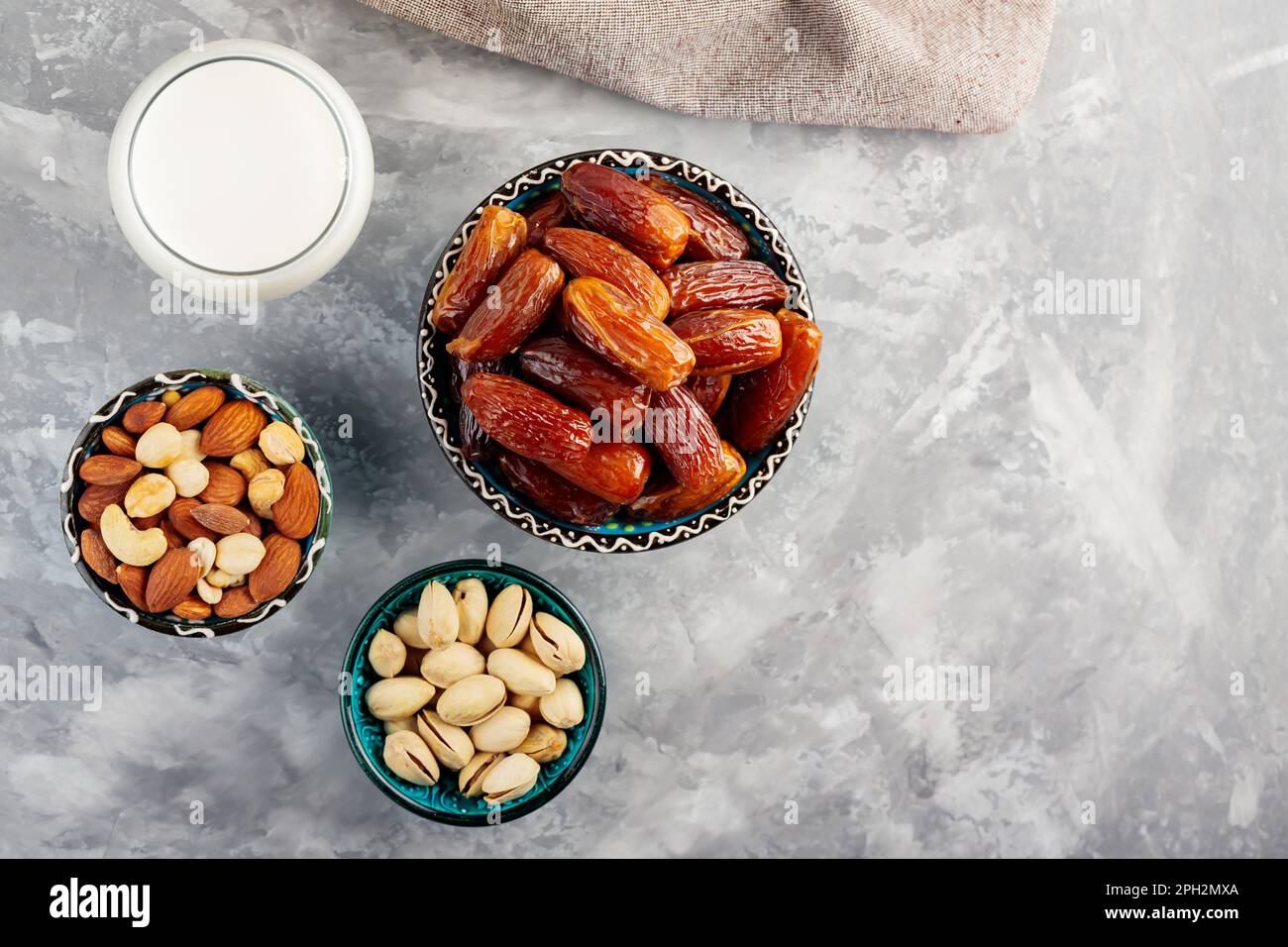 Ramadan Kareem food and drinks. Dried dates, nuts and milk on a gray ...