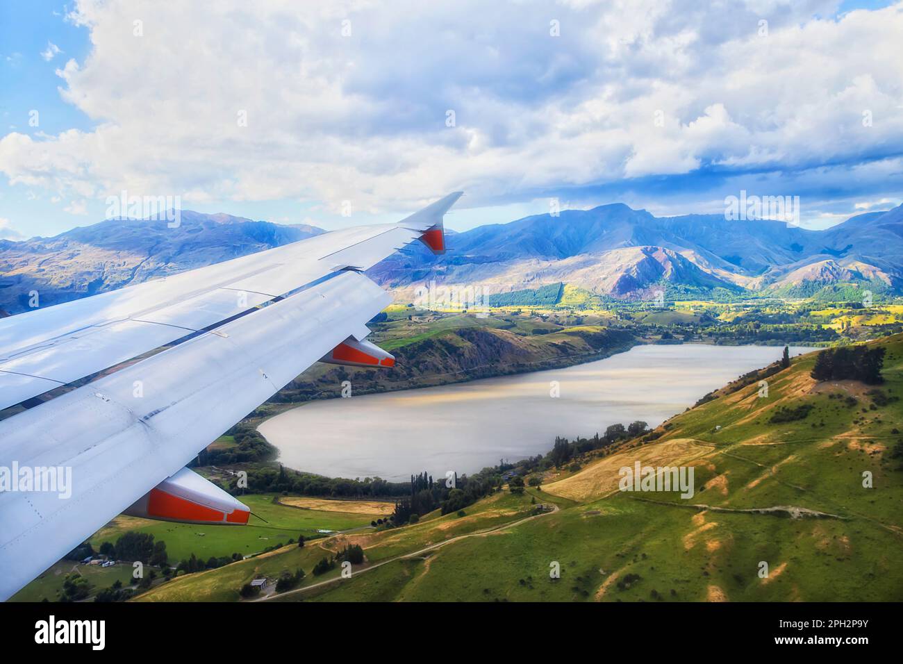Passenger airplane jet engings wing over Lake Hayes around QUeenstown ...