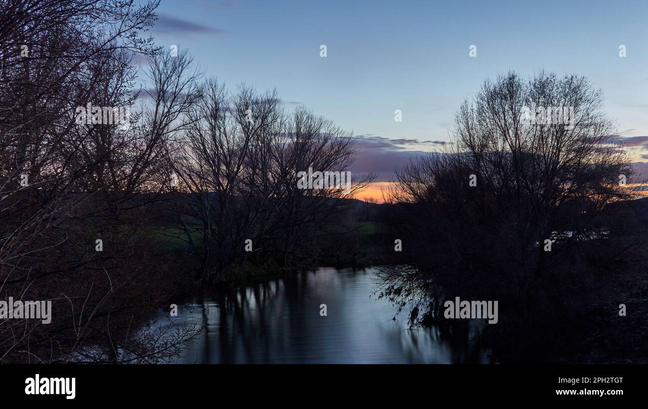 View of a river at dusk reflecting a dramatic sky. Panoramic format ...