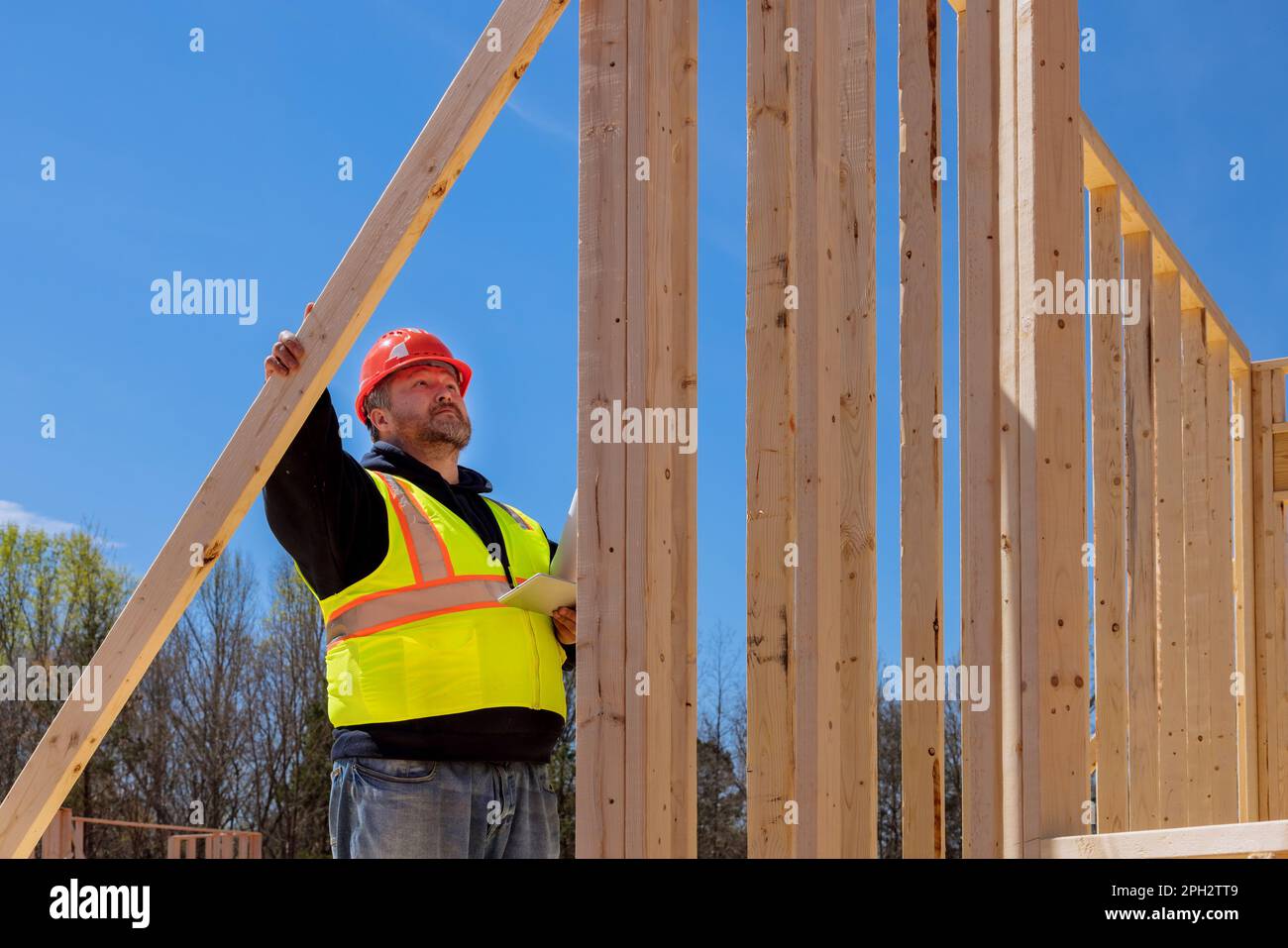 Engineers checking leveling quality of wooden beams using level on ...