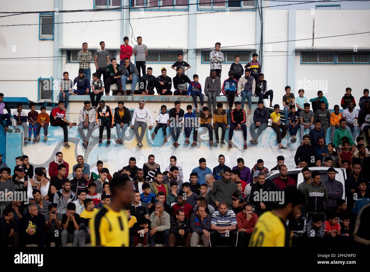 Gaza, Palestine. 25th Mar, 2023. Spectators watch a football game ...
