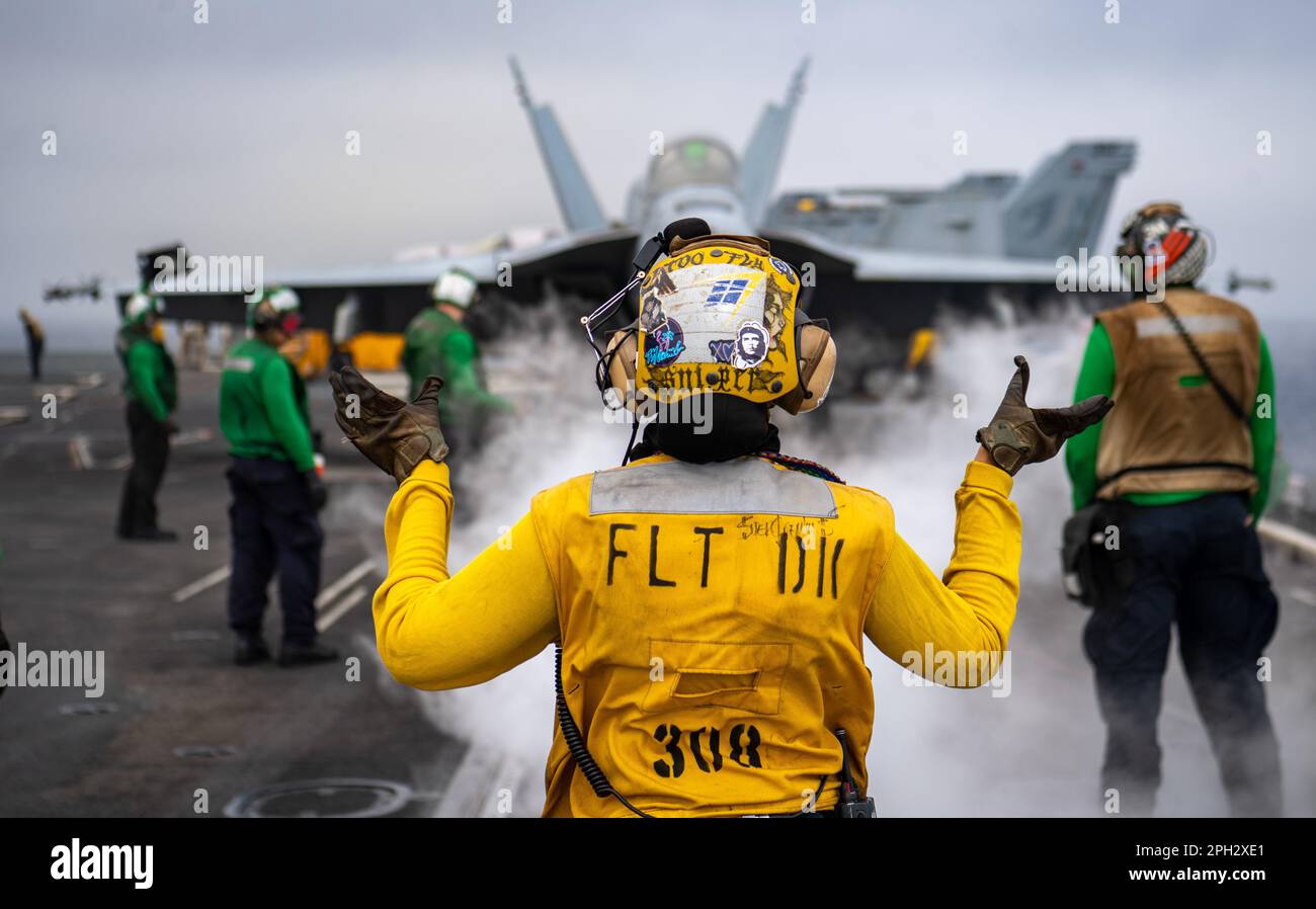 230324-N-DU622-1001 PHILIPPINE SEA (March 24, 2023) A U.S. Navy Sailor directs an F/A-18E Super ...