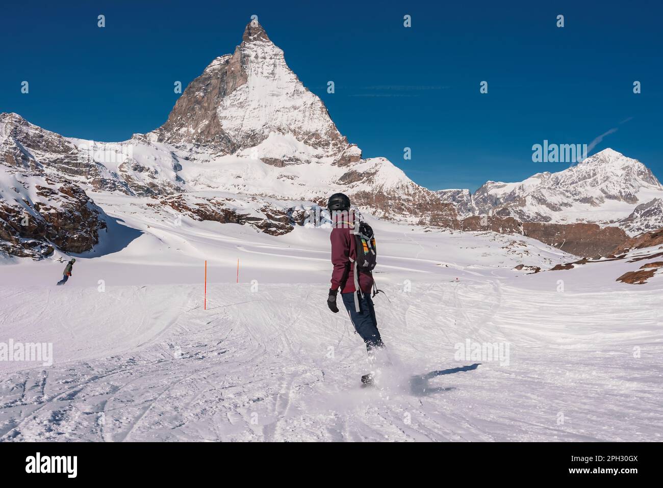 Young man snowboarding in Zermatt ski resort right next to the famous ...