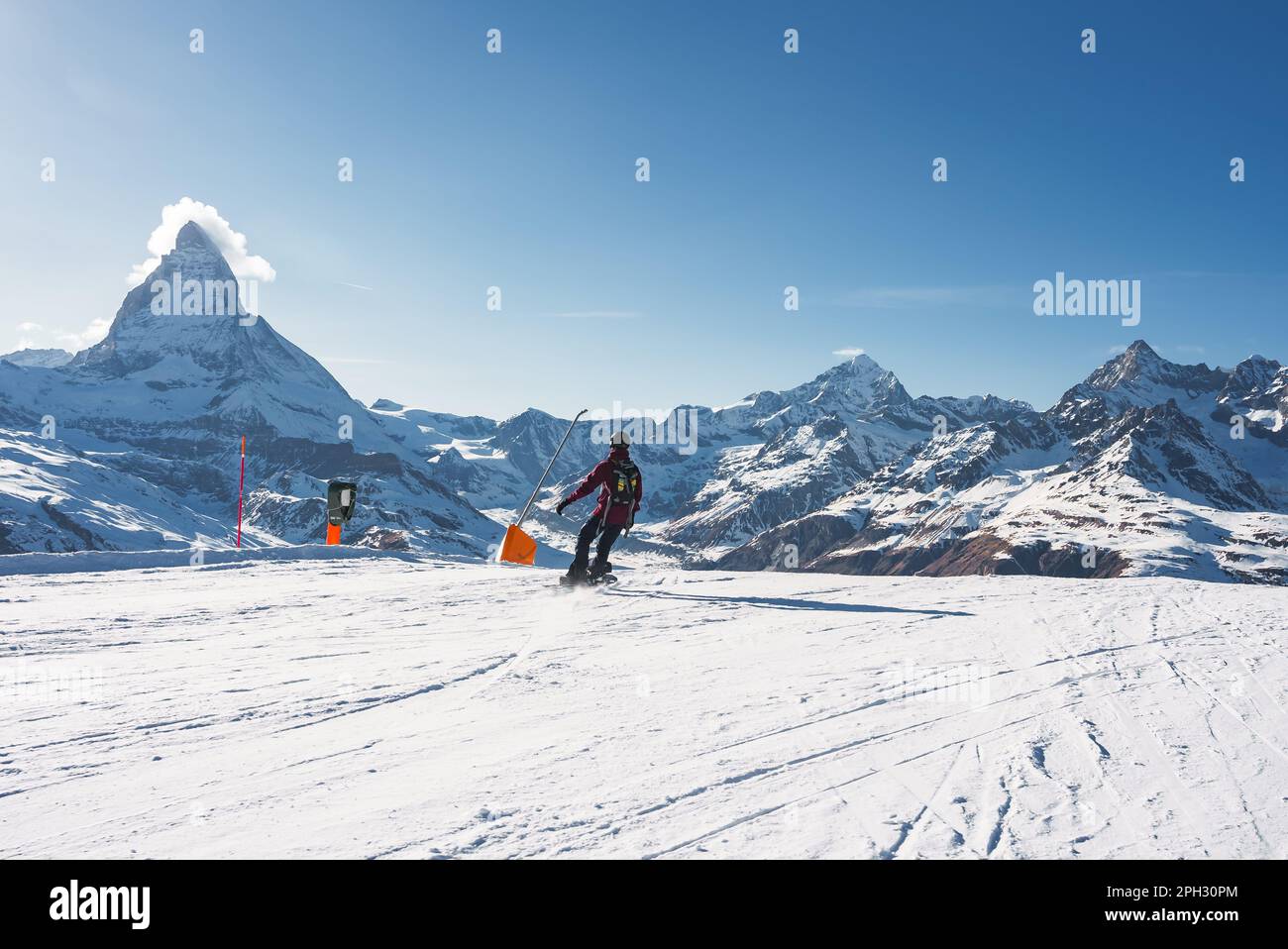 Young man snowboarding in Zermatt ski resort right next to the famous ...