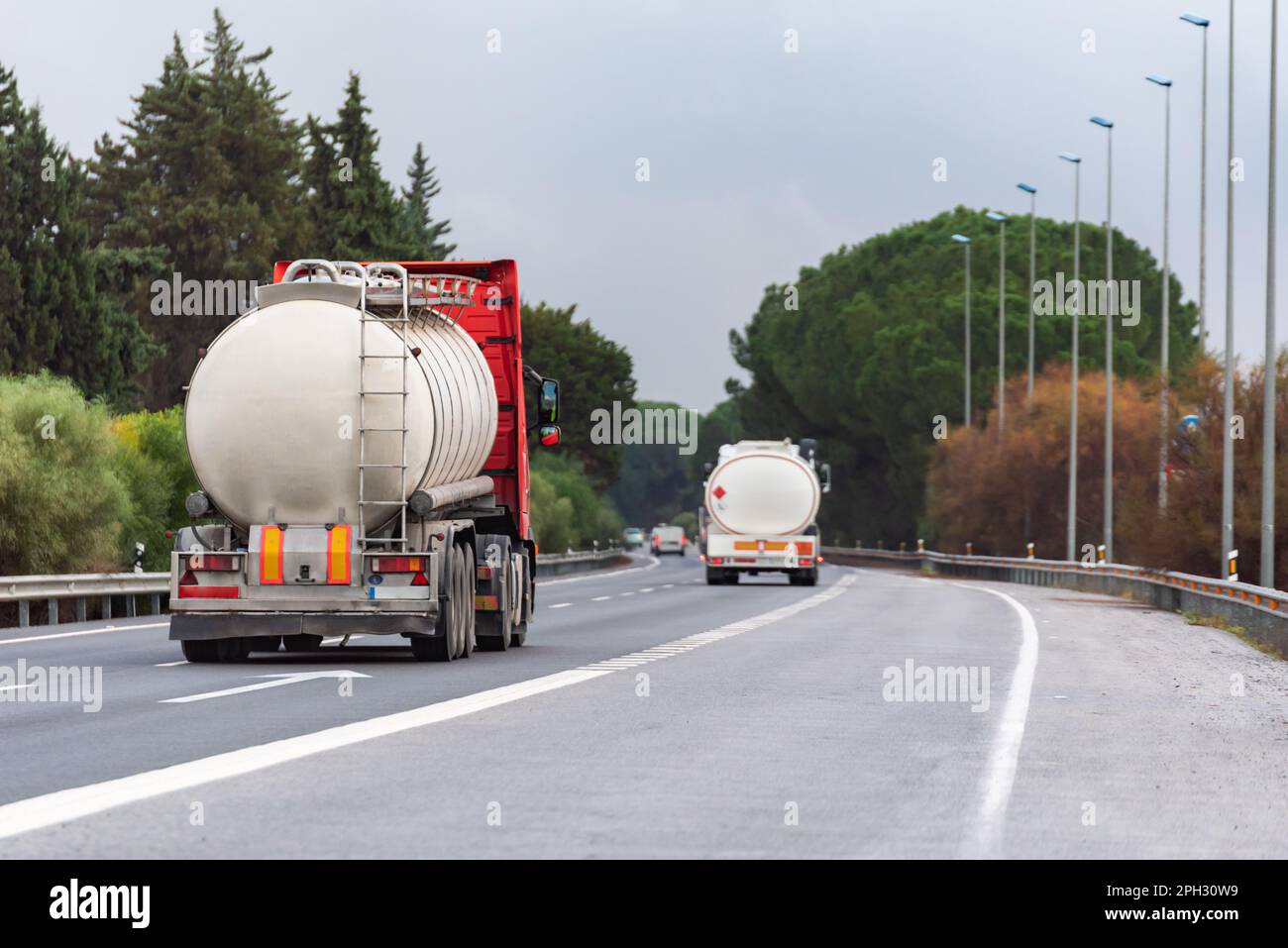 Tanker trucks driving on a highway Stock Photo - Alamy