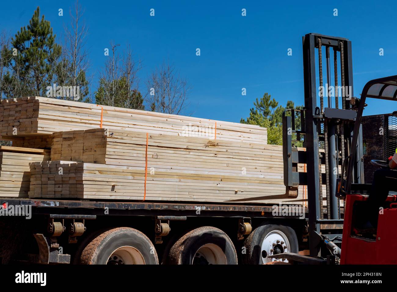 An unloading of wooden building materials on construction site is ...