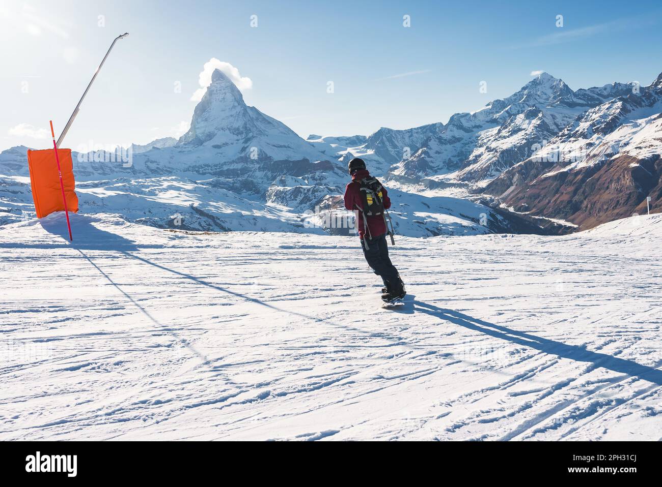 Young man snowboarding in Zermatt ski resort right next to the famous ...