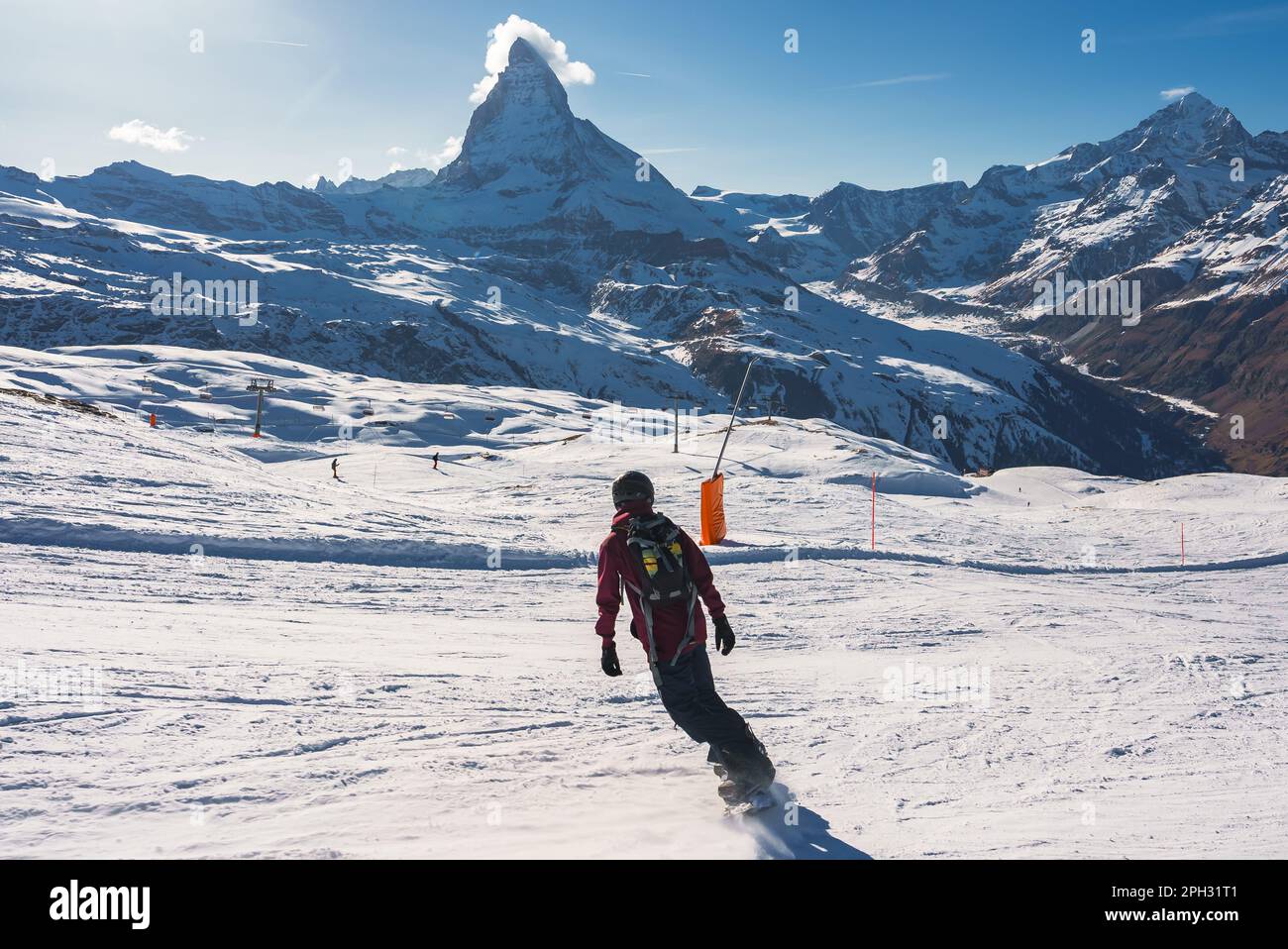 Young man snowboarding in Zermatt ski resort right next to the famous ...
